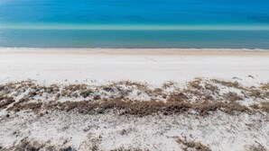 Uma praia com águas azul-claras e areia branca.