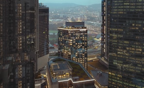 Um edifício alto com fachada de vidro moderna, rodeado por outros edifícios imponentes.