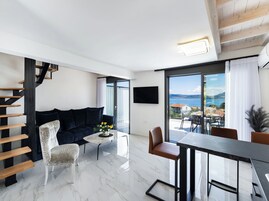 Dúplex Deluxe, vista para o mar | Sala de estar | Televisor