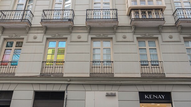 Um edifício com vários andares e uma loja Kenay no andar térreo.