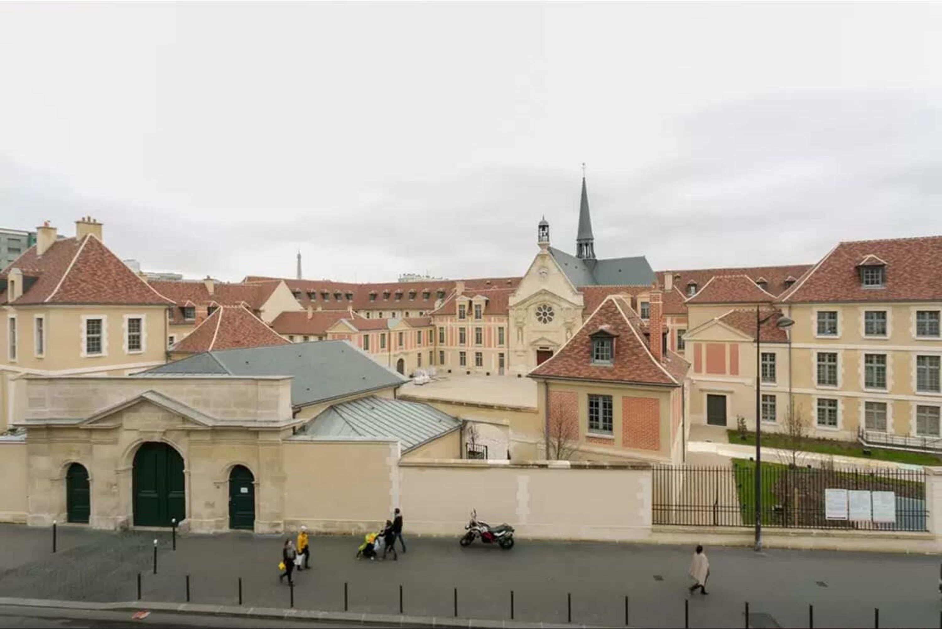 Um edifício histórico com uma torre do relógio imponente e um pátio central.