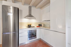 Um frigorífico, um micro-ondas, um forno, uma placa de cozinha 