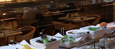 Um buffet com diversos pratos e utensílios.