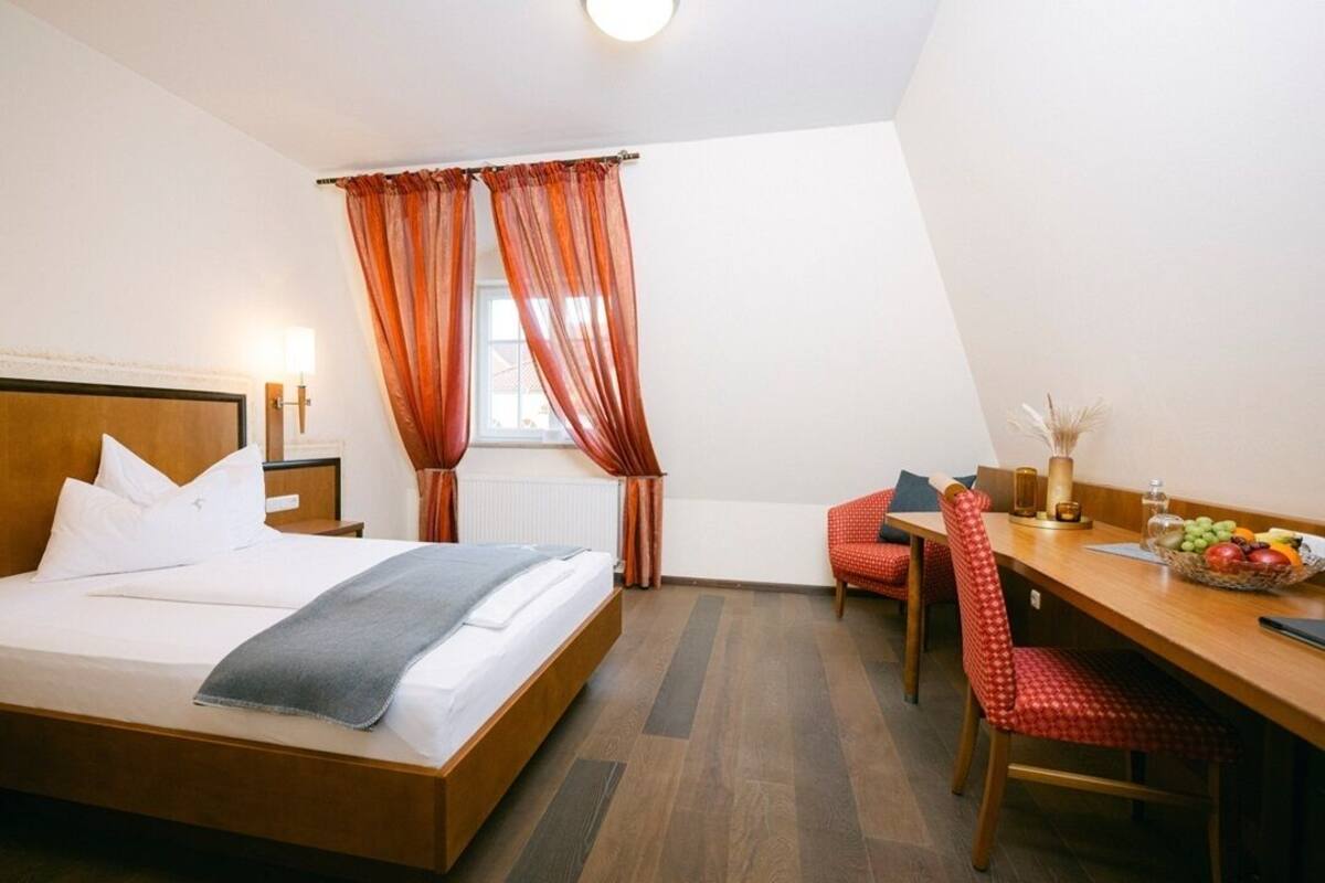 Um quarto com uma cama, uma escrivaninha e uma cadeira.