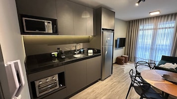 Um frigorífico, um micro-ondas, um forno, uma placa de cozinha