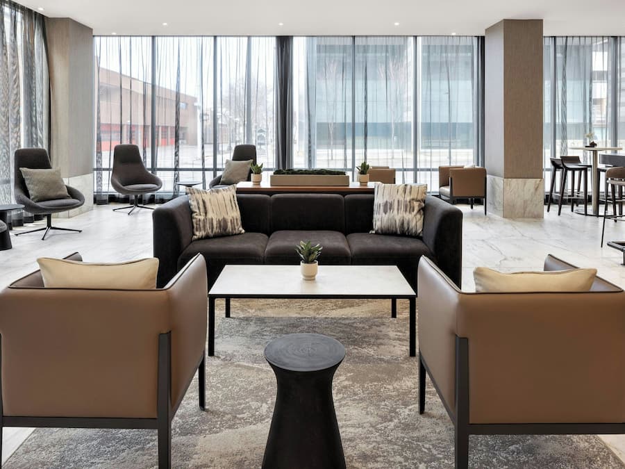 Uma área de estar moderna com sofás de couro, uma mesa de centro e um bar com banquetes.
