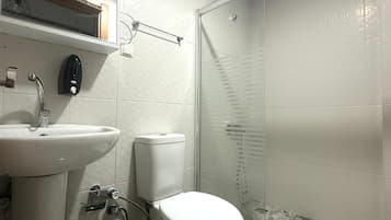 Chuveiro, toalhas de banho, sabonete, shampoo