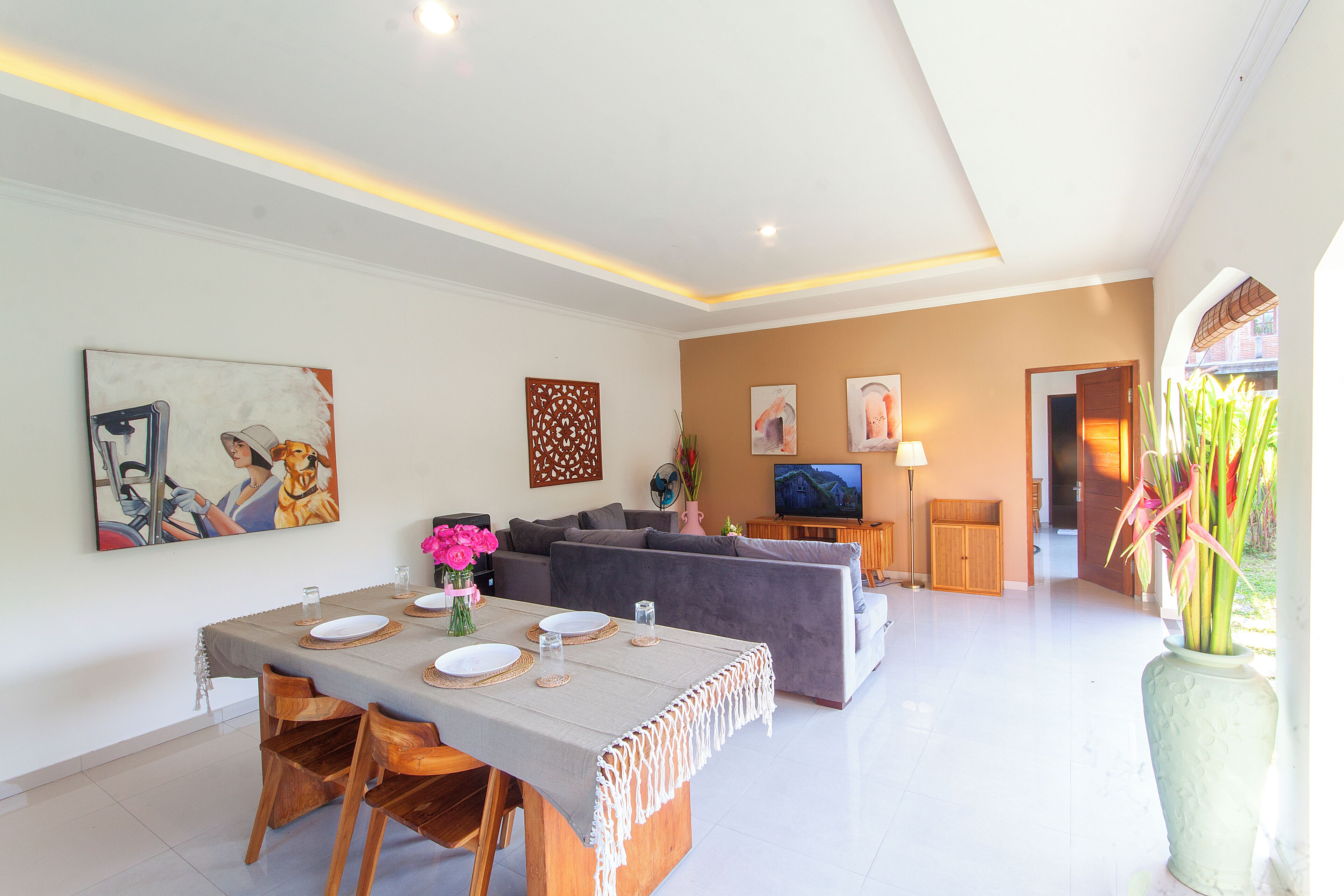 Uma sala de estar moderna com área de jantar, sofás e televisão.