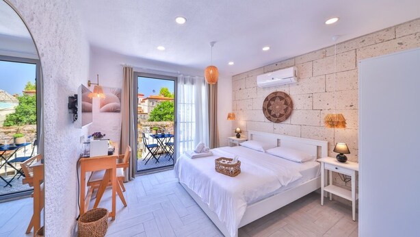 Um quarto com uma cama, mesas de cabeceira, uma escrivaninha e uma cadeira.