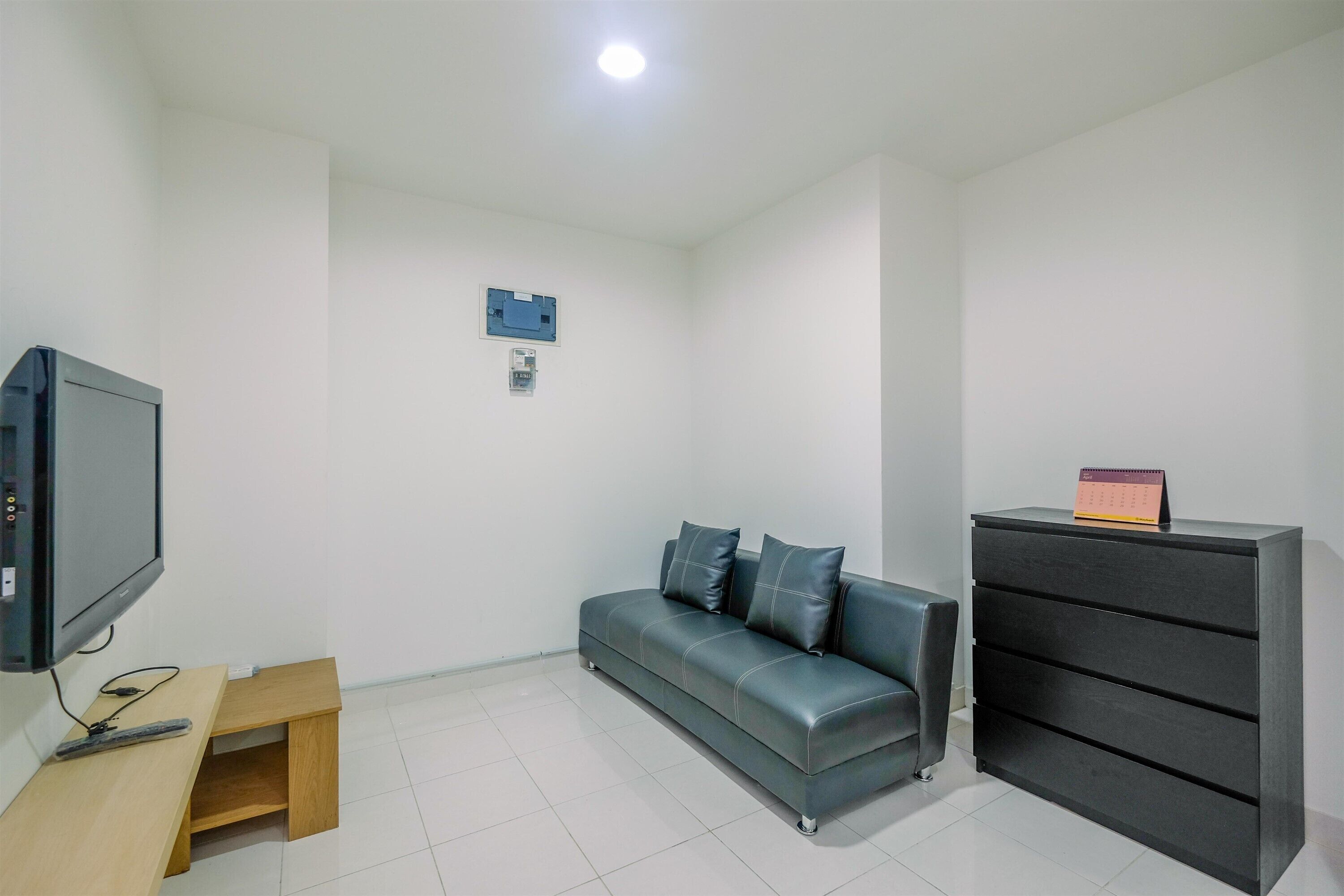 Uma sala de estar moderna com um sofá cinzento, uma mesa de centro de madeira, um móvel para televisão preto e um armário de escritório preto.
