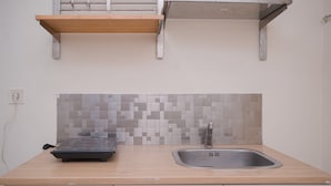 Uma cozinha com bancada de madeira, pia e painel de azulejos.