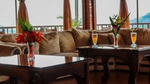 Uma área de estar acolhedora com sofás de couro, uma mesa de centro de madeira e um vaso com flores.