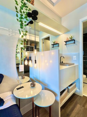 Cozinha moderna com bancada branca, plantas pendentes e iluminação pendente.