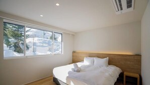 Quarto moderno com uma janela grande, cabeceira de madeira e cama bem arrumada.