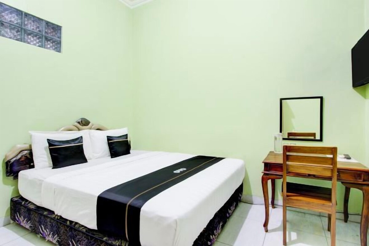 Quarto com cama, escrivaninha e cadeira.