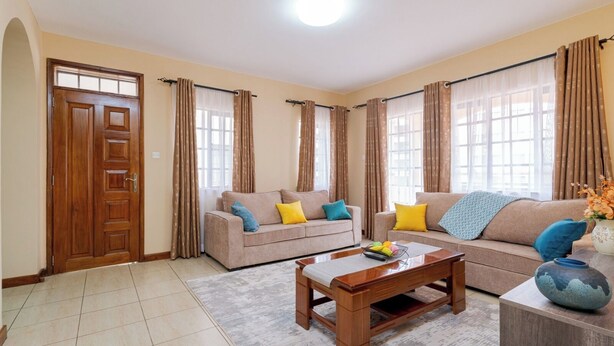 Uma sala de estar com dois sofás, uma mesa de centro e um armário de madeira.