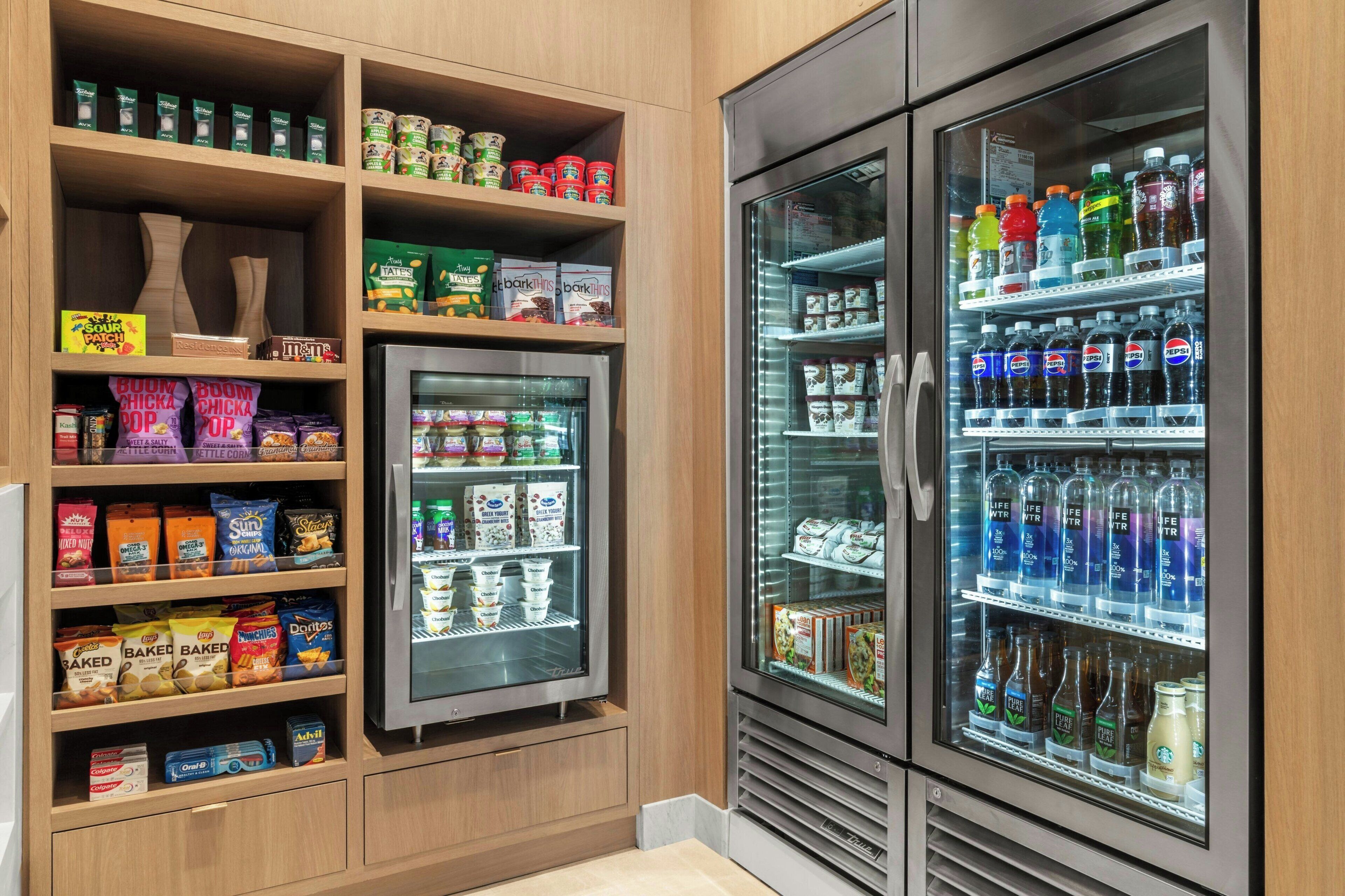 Vitrine refrigerada com diversas bebidas e lanches.