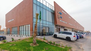 Um edifício moderno com fachada de vidro e uma placa com a inscrição 'Dafih'.