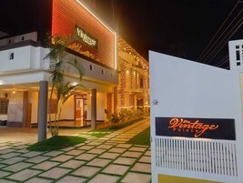 Um edifício com uma placa indicando "Vintage Place" e uma entrada bem iluminada, com um caminho que leva à porta.