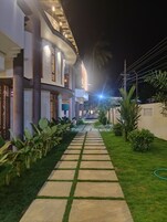 Uma passagem bem iluminada que leva a um edifício moderno, com área externa coberta.