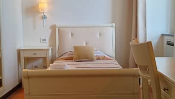 Quarto com cama, mesa de cabeceira, cadeira e abajur.