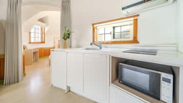 Cozinha moderna com micro-ondas embutido, pia e janela sobre a bancada.