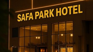 Exterior do Safa Park Hotel, com sinalização iluminada, janelas amplas e design arquitetônico moderno.