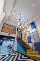 Um interior moderno com escada, piso estampado e teto com luminárias pendentes.