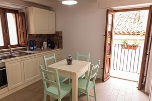 Apartamento família, sacada | Cozinha privada | Cadeirão de bebê
