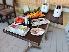 Uma mesa de madeira com uma variedade de frutas, vegetais e acompanhamentos para o café da manhã.