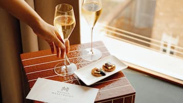 Uma mesa com duas taças de vinho, um prato com comida e um menu numa caixa de madeira.