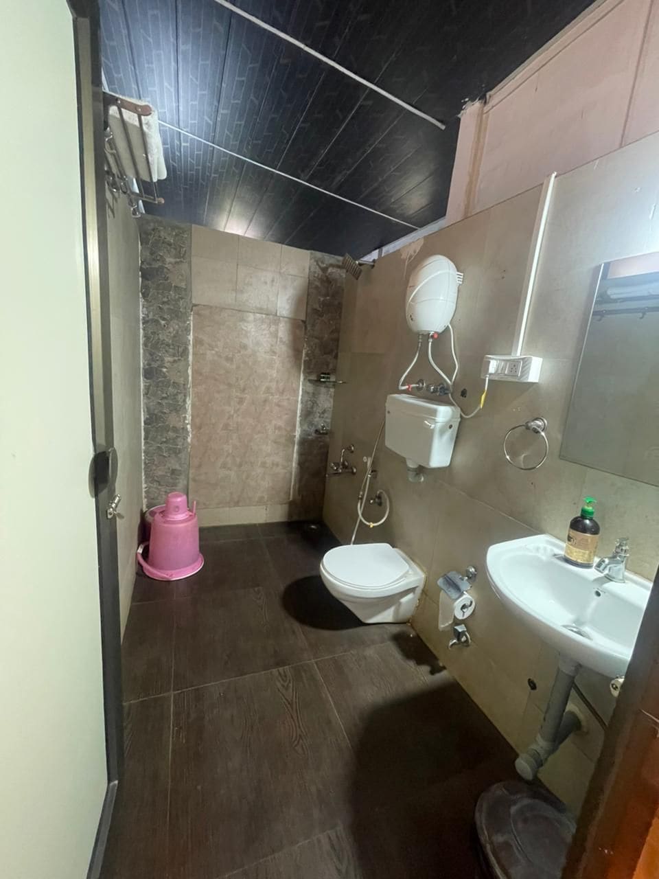 Uma casa de banho pequena com sanita, lavatório e chuveiro.