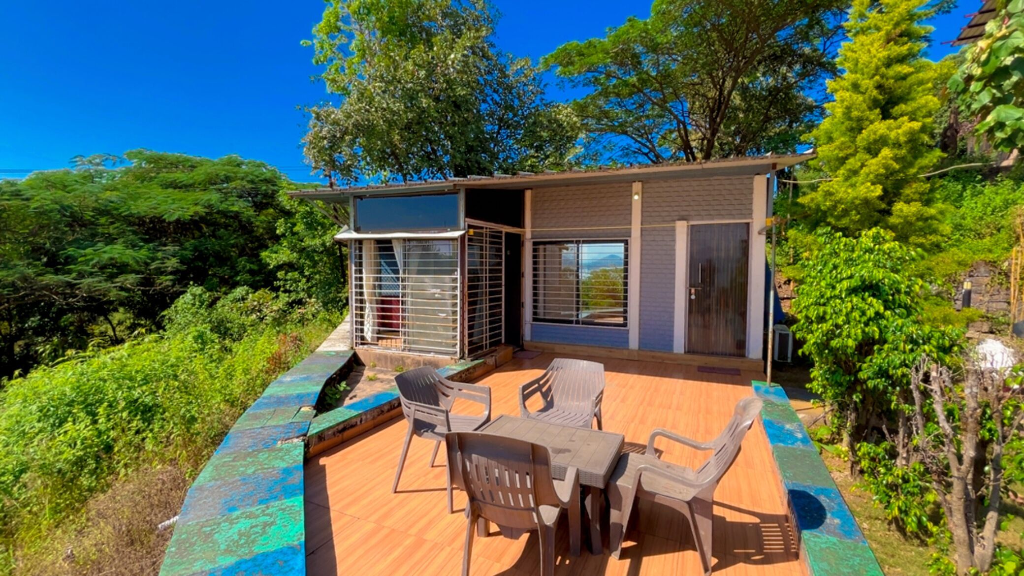 Uma casa moderna com um pátio, uma mesa de jantar e cadeiras.