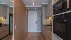 Uma cozinha moderna com armários de madeira, eletrodomésticos de aço inoxidável e forno embutido.