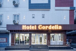 Hotel Cordelia com uma placa iluminada em destaque, janelas amplas e fachada moderna.