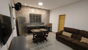 Um espaço compacto com cozinha compacta, área de refeições e sofá.