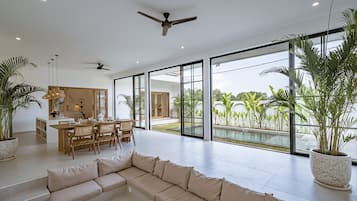 Villa Deluxe, 3 quartos, pátio, vista para a piscina | Sala | Televisor de 43 polegadas com canais por cabo