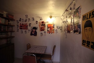 Um quarto com uma mesa, cadeiras e uma estante.