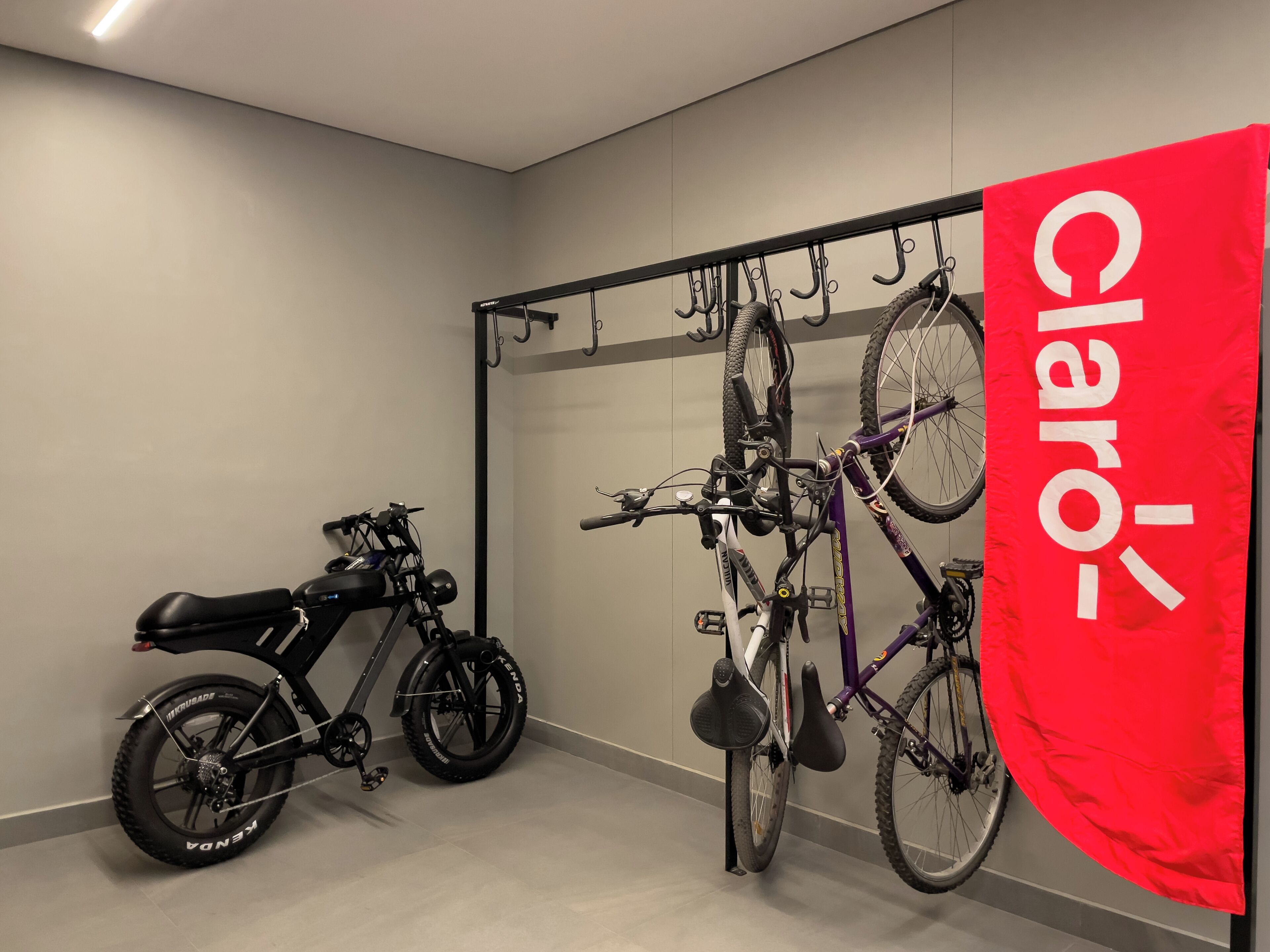 Uma área de armazenamento de bicicletas com duas bicicletas e um patinete.
