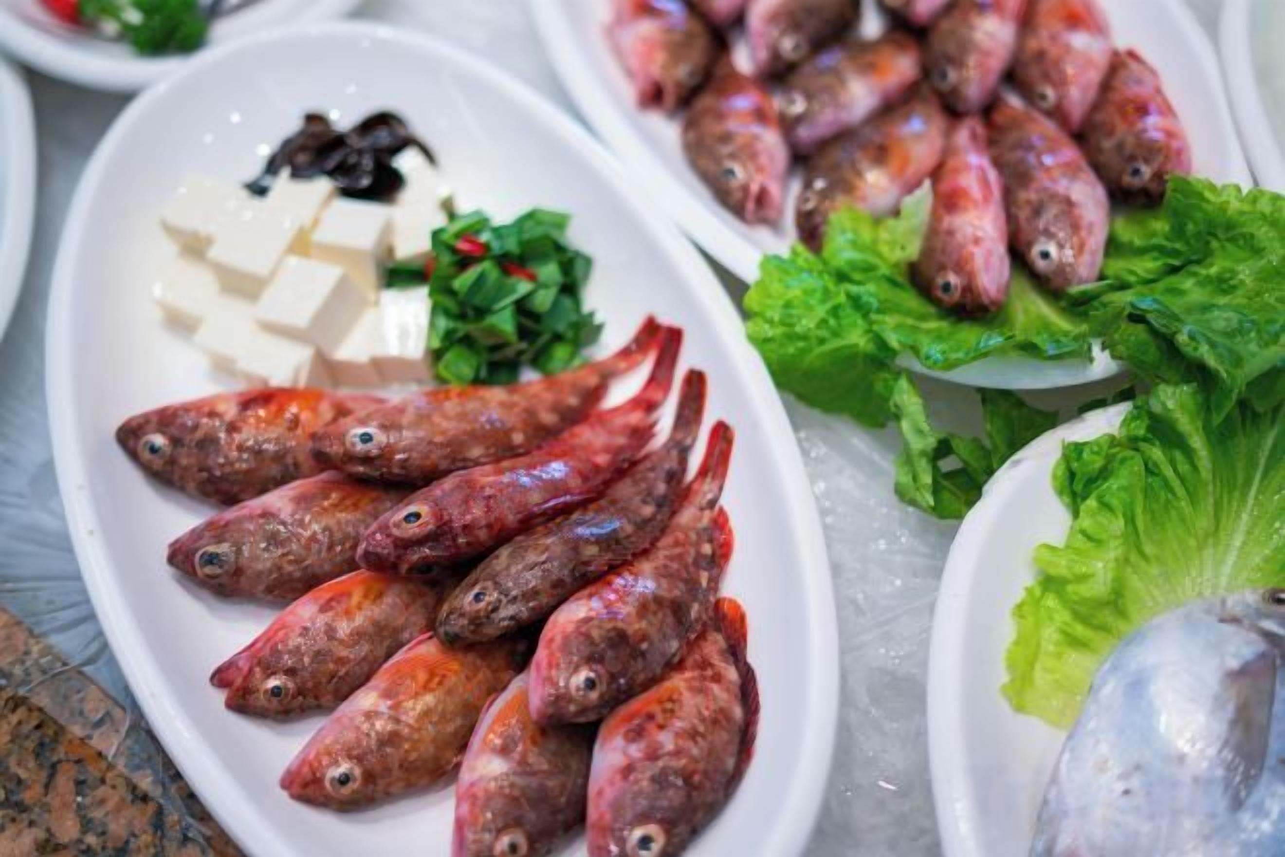 Prato de peixe grelhado e legumes sobre uma mesa.