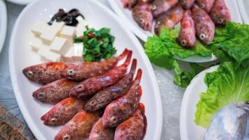 Prato de peixe grelhado e legumes sobre uma mesa.