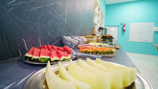 Buffet com diversas frutas e uma parede de mármore.