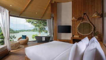 Quarto moderno com cama grande, televisão de tela plana, teto de madeira e vista para um lago.
