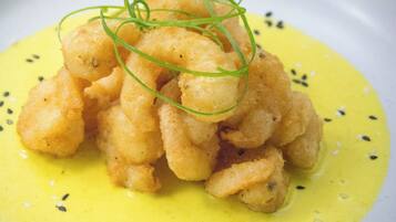 Um prato de comida com molho amarelo e guarnição verde.