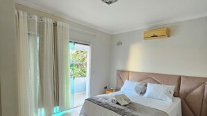 Quarto com cama, cortinas, luminária no teto e janela.