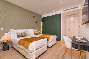 Quarto moderno com duas camas, uma escrivaninha e uma cadeira.