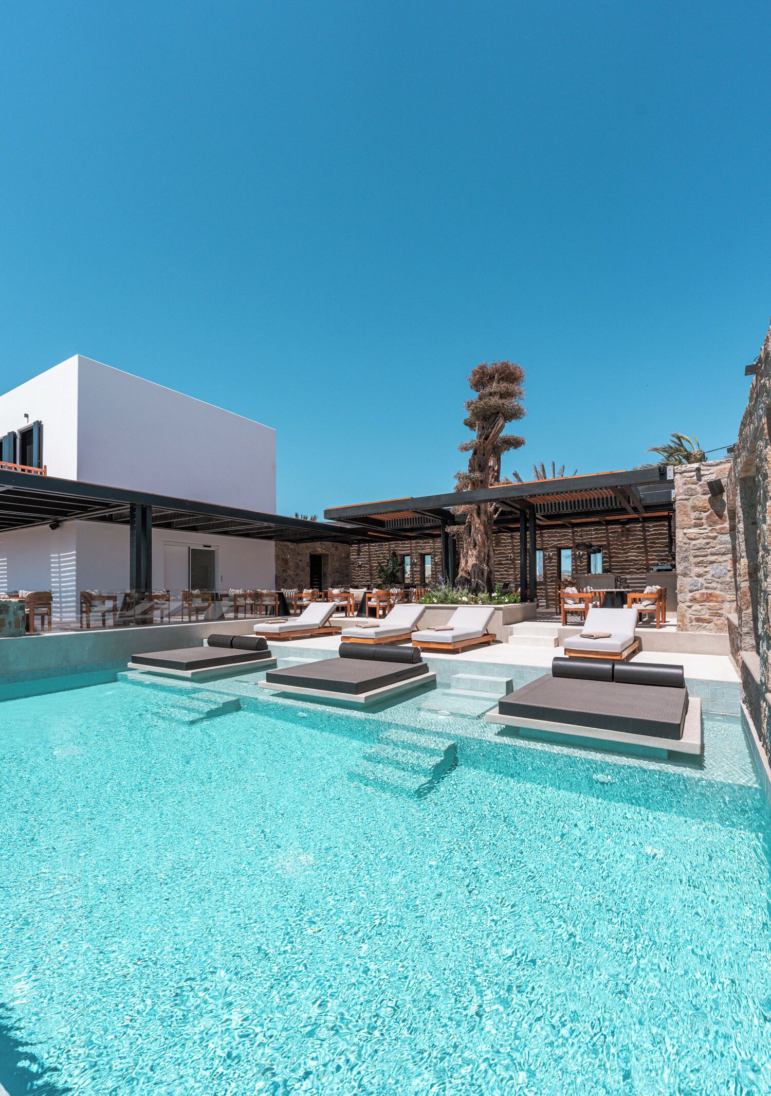 Uma área de piscina com espreguiçadeiras e um pérgola.