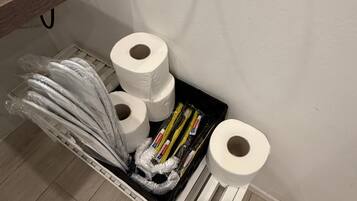Armário com papel higiênico, produtos de limpeza e um saco plástico.