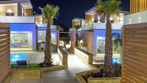 Uma villa moderna com piscina, área de estar externa e um pátio bem iluminado.
