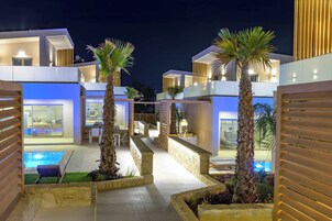 Uma villa moderna com piscina, área de estar externa e um pátio bem iluminado.